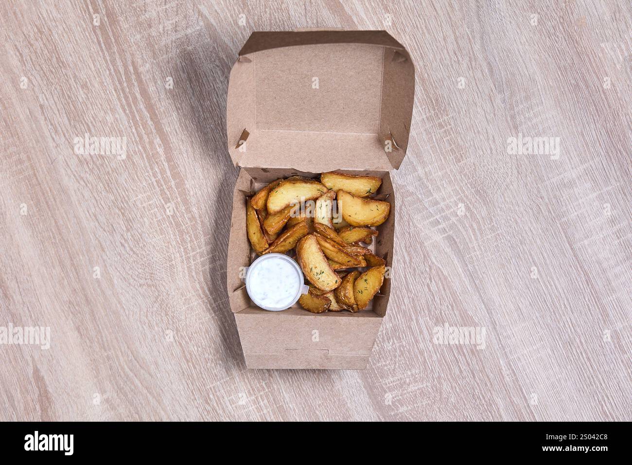 Crispy baked potato wedges with sauce in a cardboard box Stock Photo ...