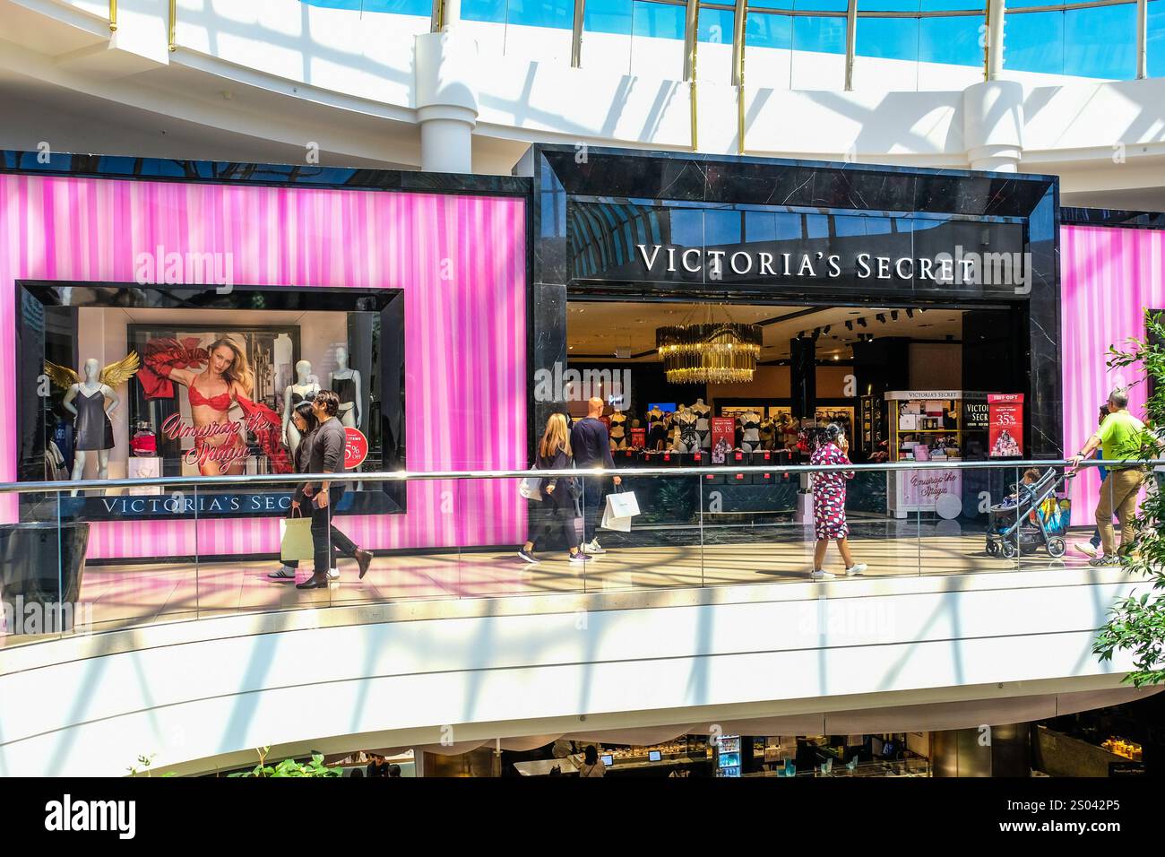 People are seen in front of Victoria Secret store during Christmas eve ...