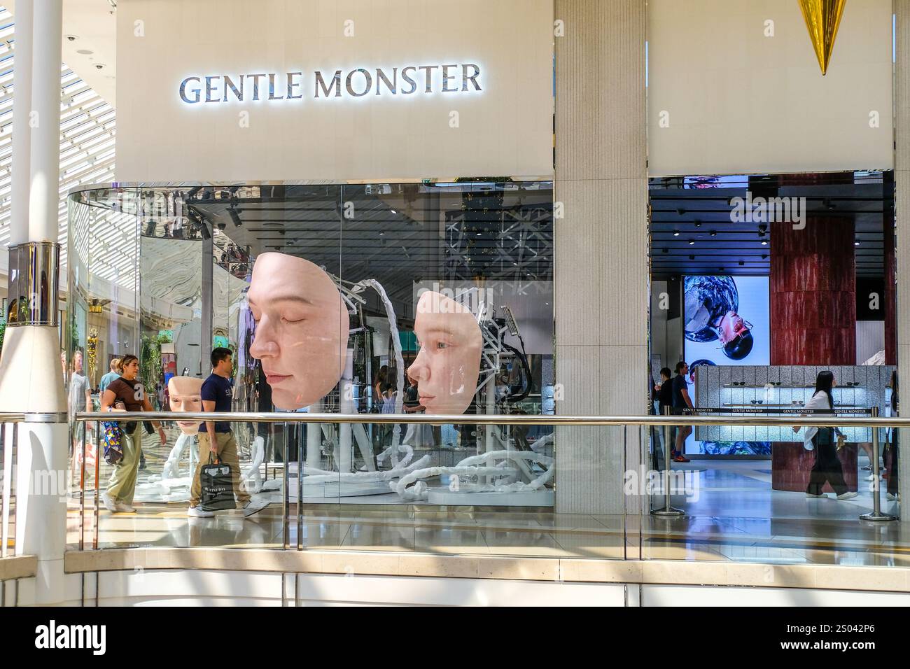 Shoppers walk past Gentle Monster eyewear store featuring robotic faces ...