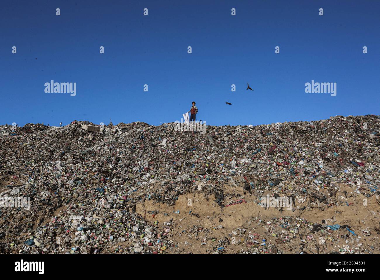 A view of the area where people live in makeshift tents near trash ...