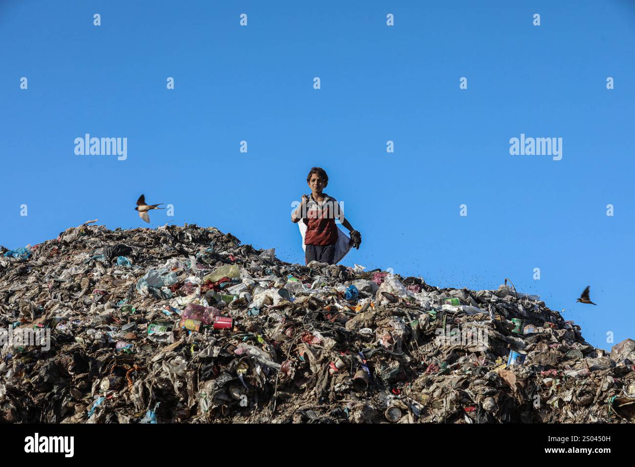 A view of the area where people live in makeshift tents near trash ...
