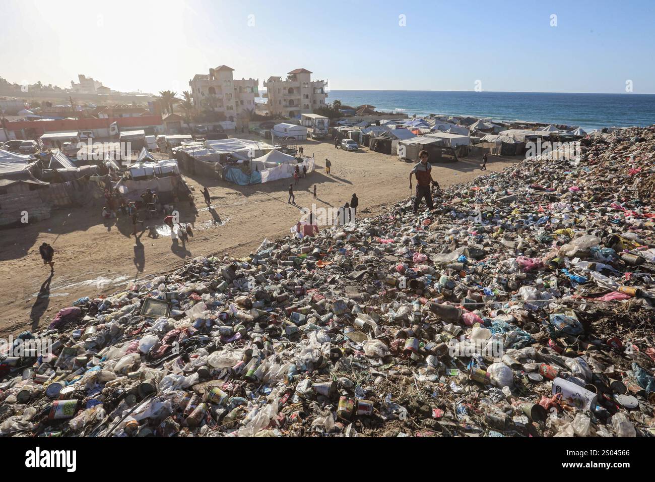 A view of the area where people live in makeshift tents near trash ...