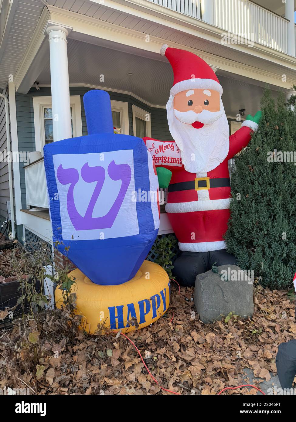 Santa Claus and a large dreidel on a front lawn, symbols of Christmas ...