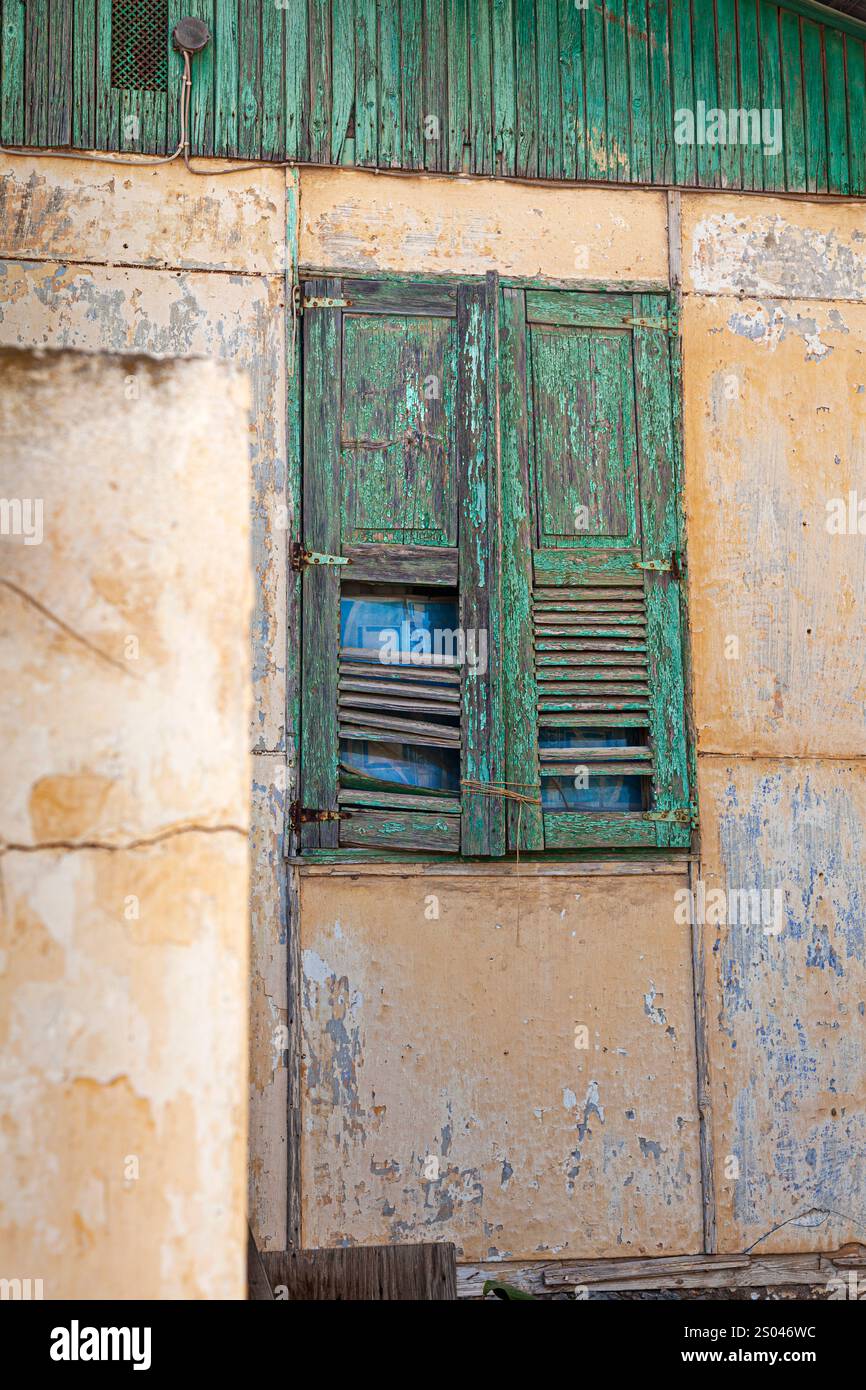 A rustic green wooden shutter on an old weathered wall in Lavrio ...