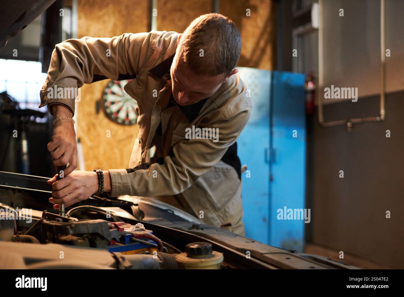 Mechanic using tools to repair engine of the car in garage Stock Photo ...