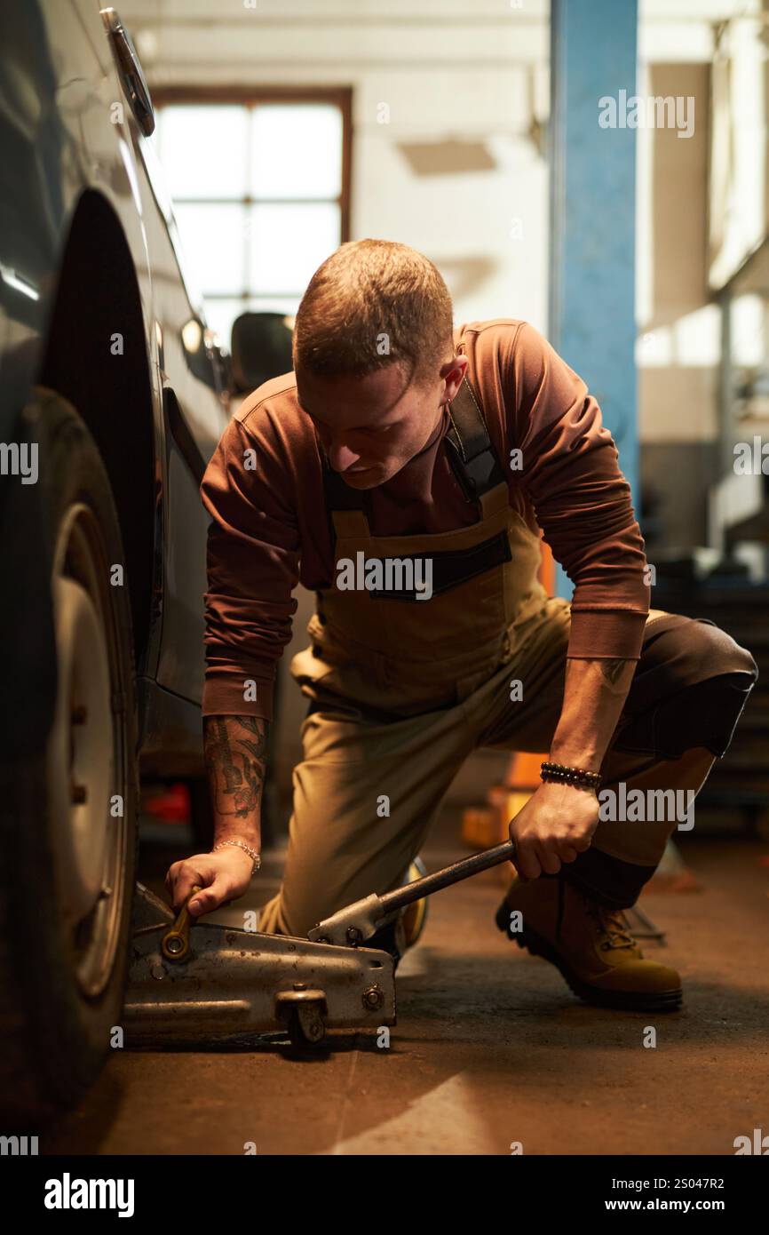Worker using equipment to change wheels of the car in service Stock ...