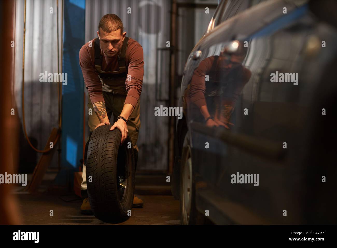 Worker changing tires in car during his work in tire service Stock ...