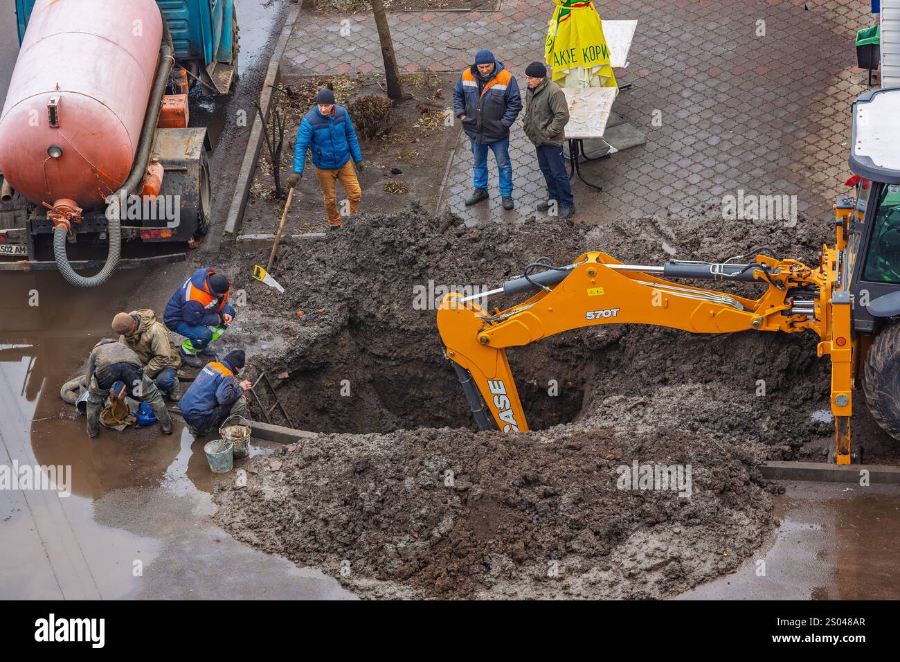 Ukraine, Romny, December 24, 2024: A group of workers repair a damaged ...