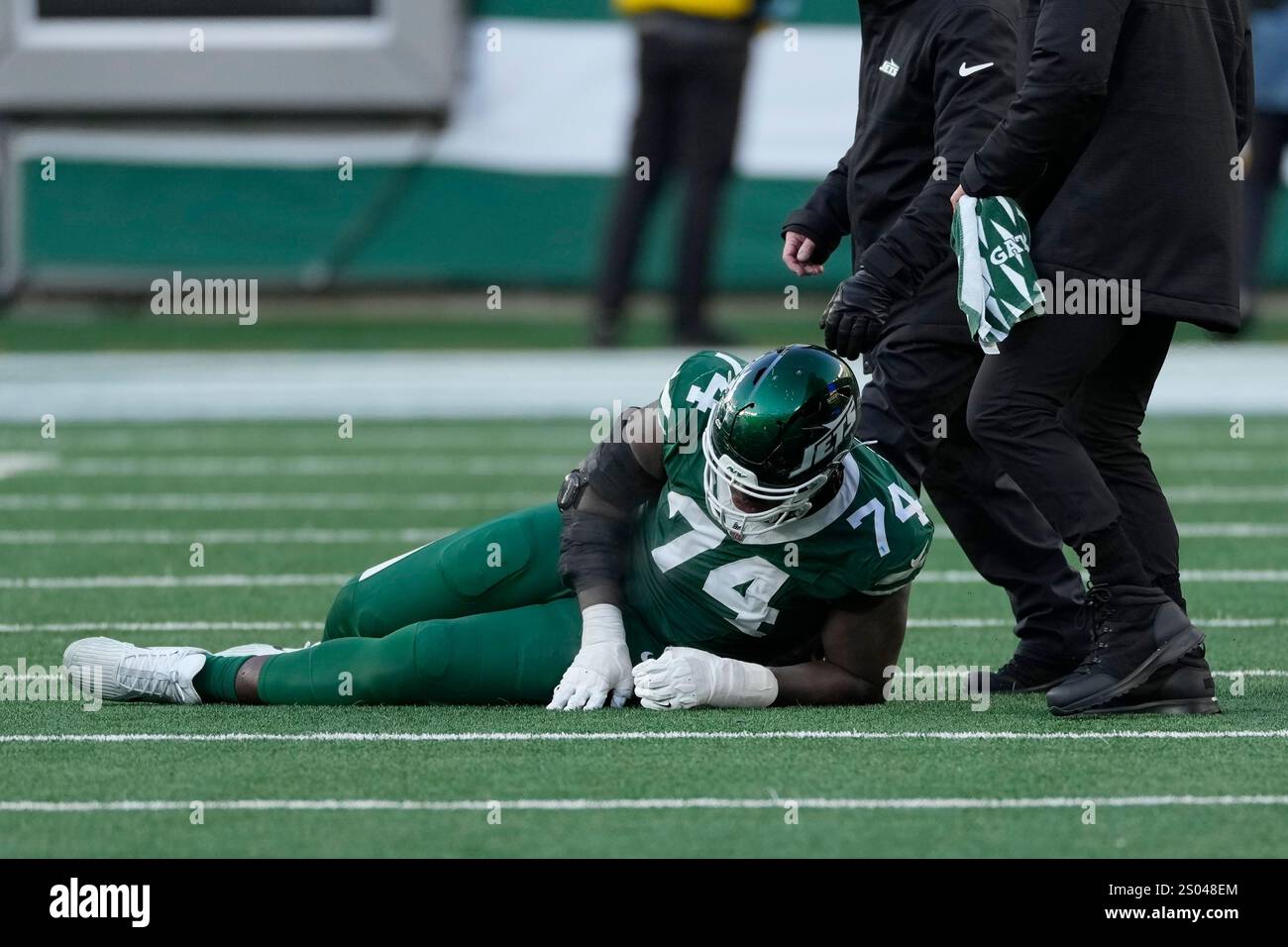 FILE - New York Jets offensive tackle Olu Fashanu (74) is checked on by ...