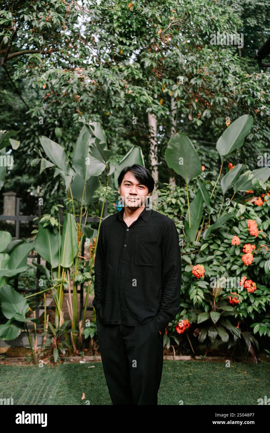A Southeast Asian man smiling warmly while looking straight ahead ...