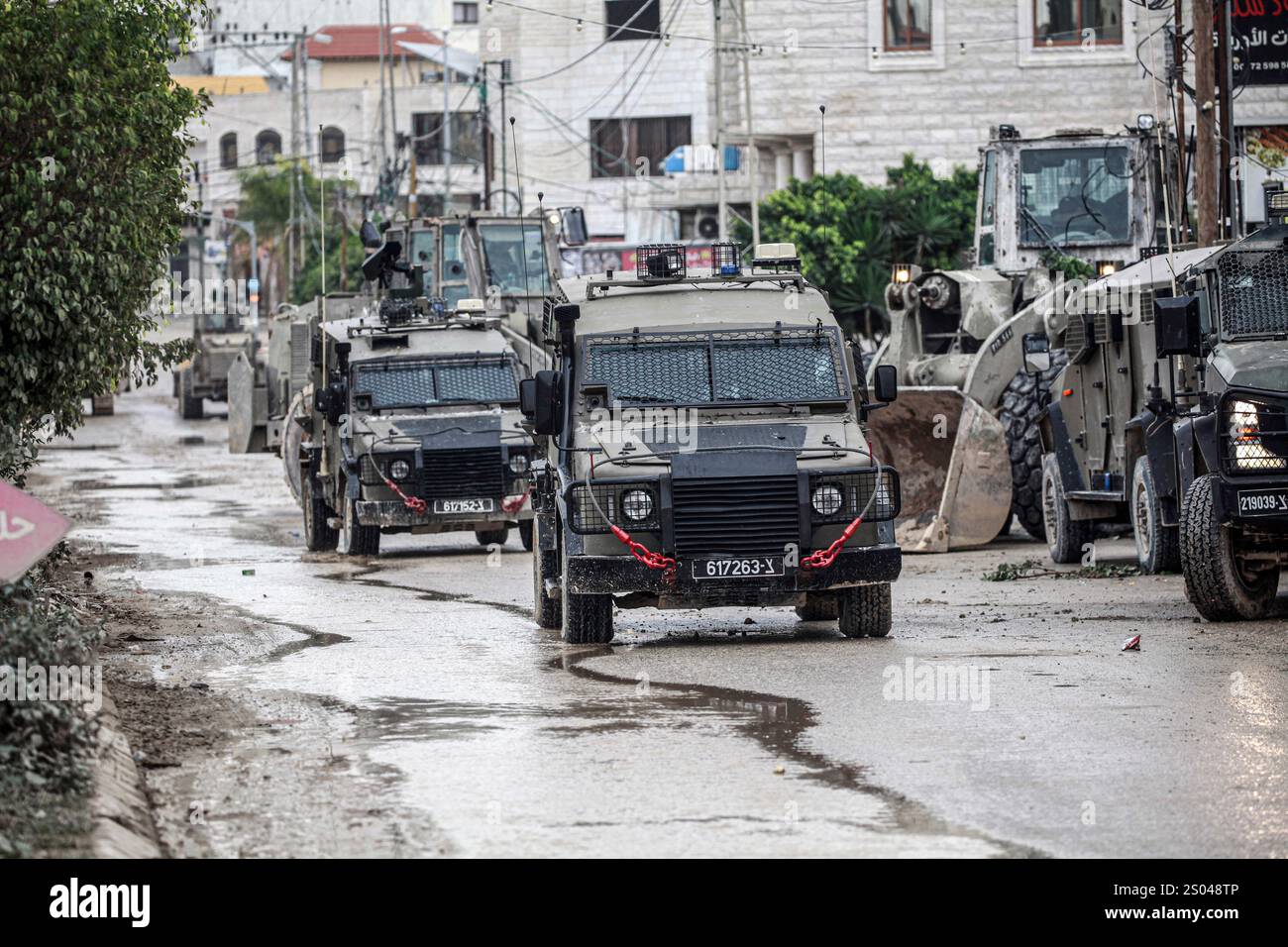 Israeli military vehicles close the street during an Israeli raid on ...