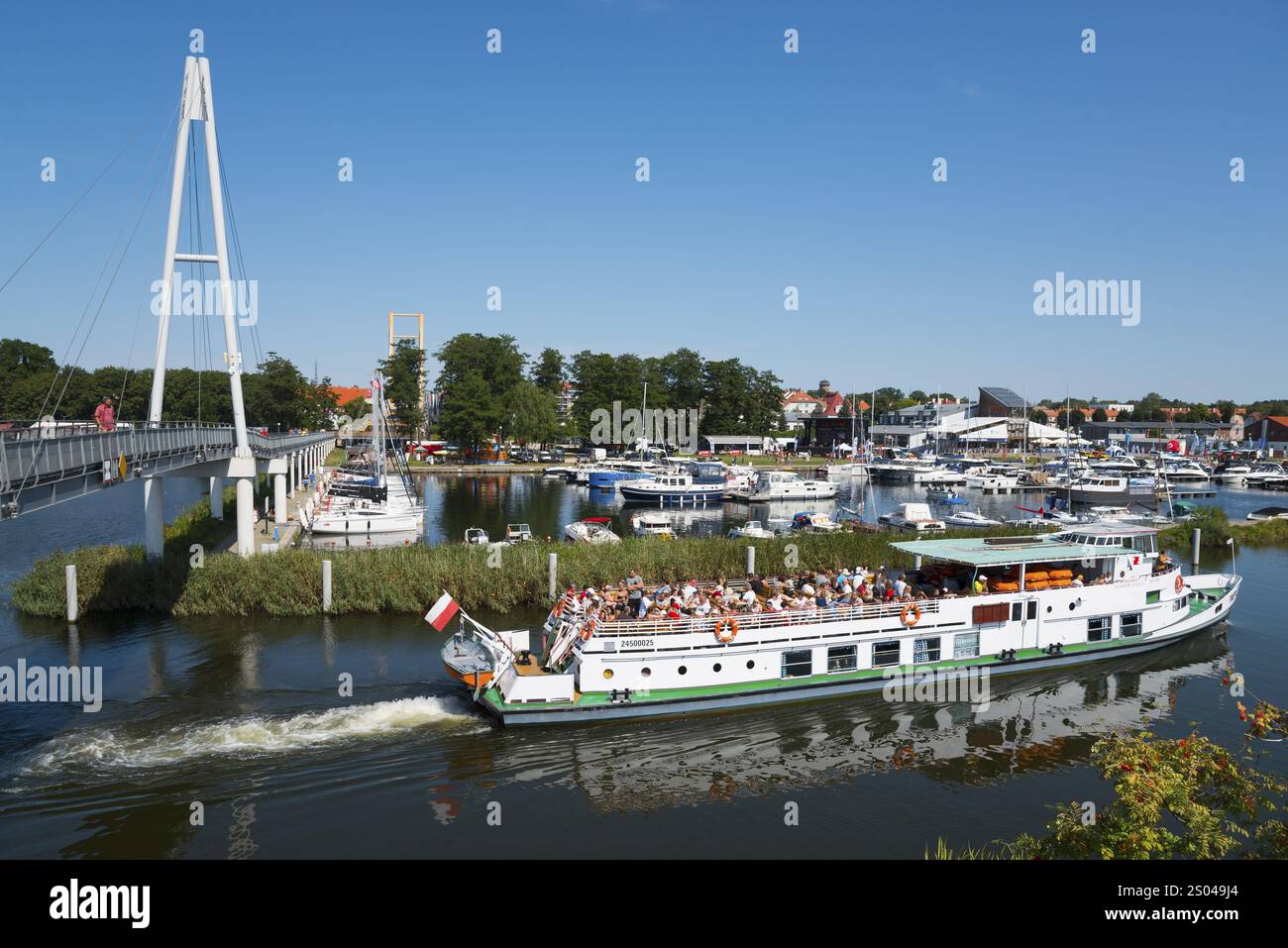 A passenger ship sails through a busy harbour full of boats, ship Talty ...