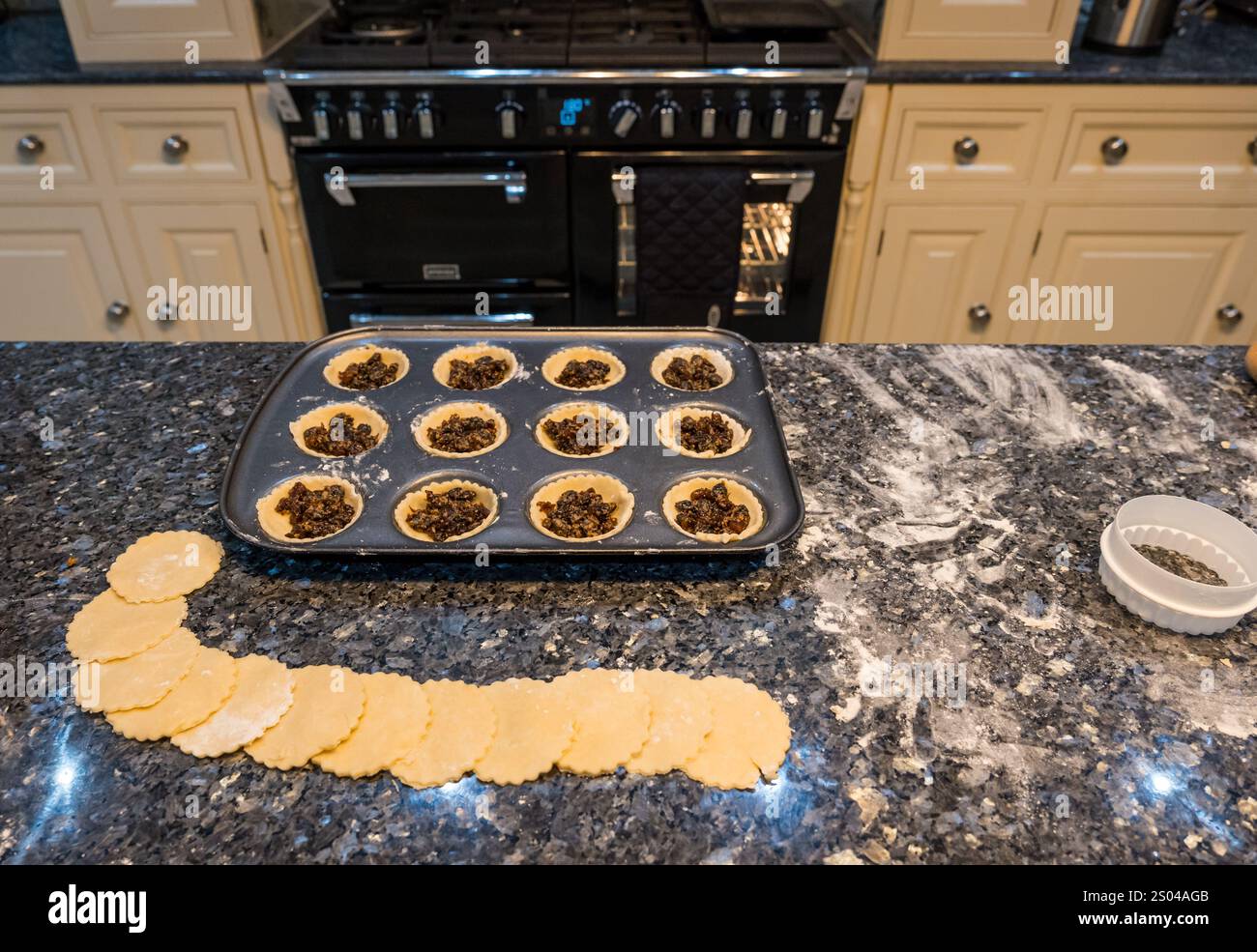 Making mince pies with pastry cases on a granite kitchen counter for ...
