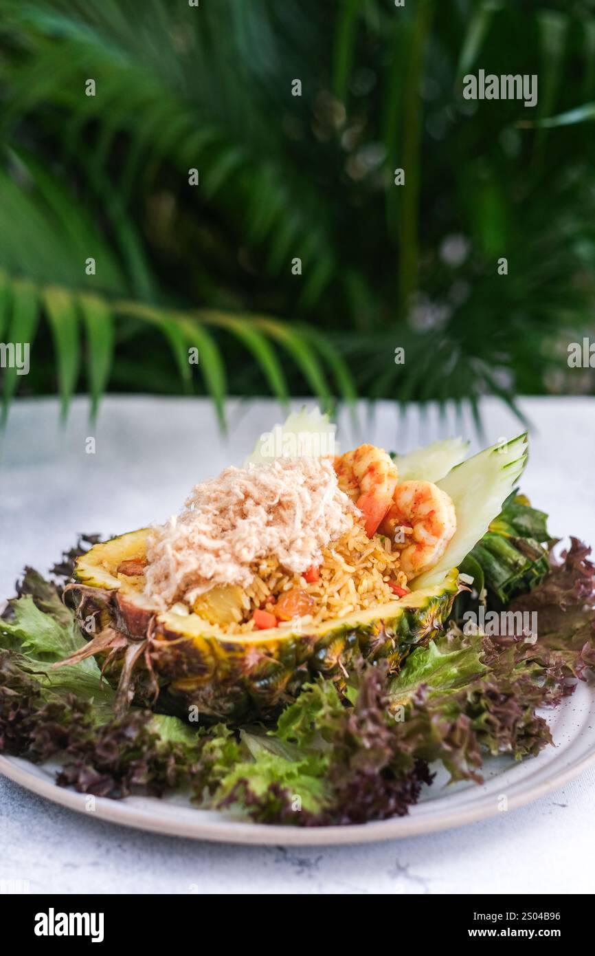Exotic pineapple fried rice served in a pineapple boat, garnished with ...
