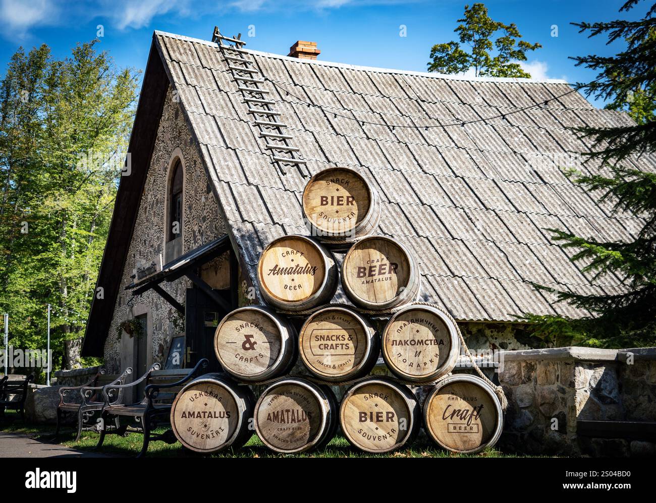 A rustic stone building with a sloped roof, featuring stacked wooden ...