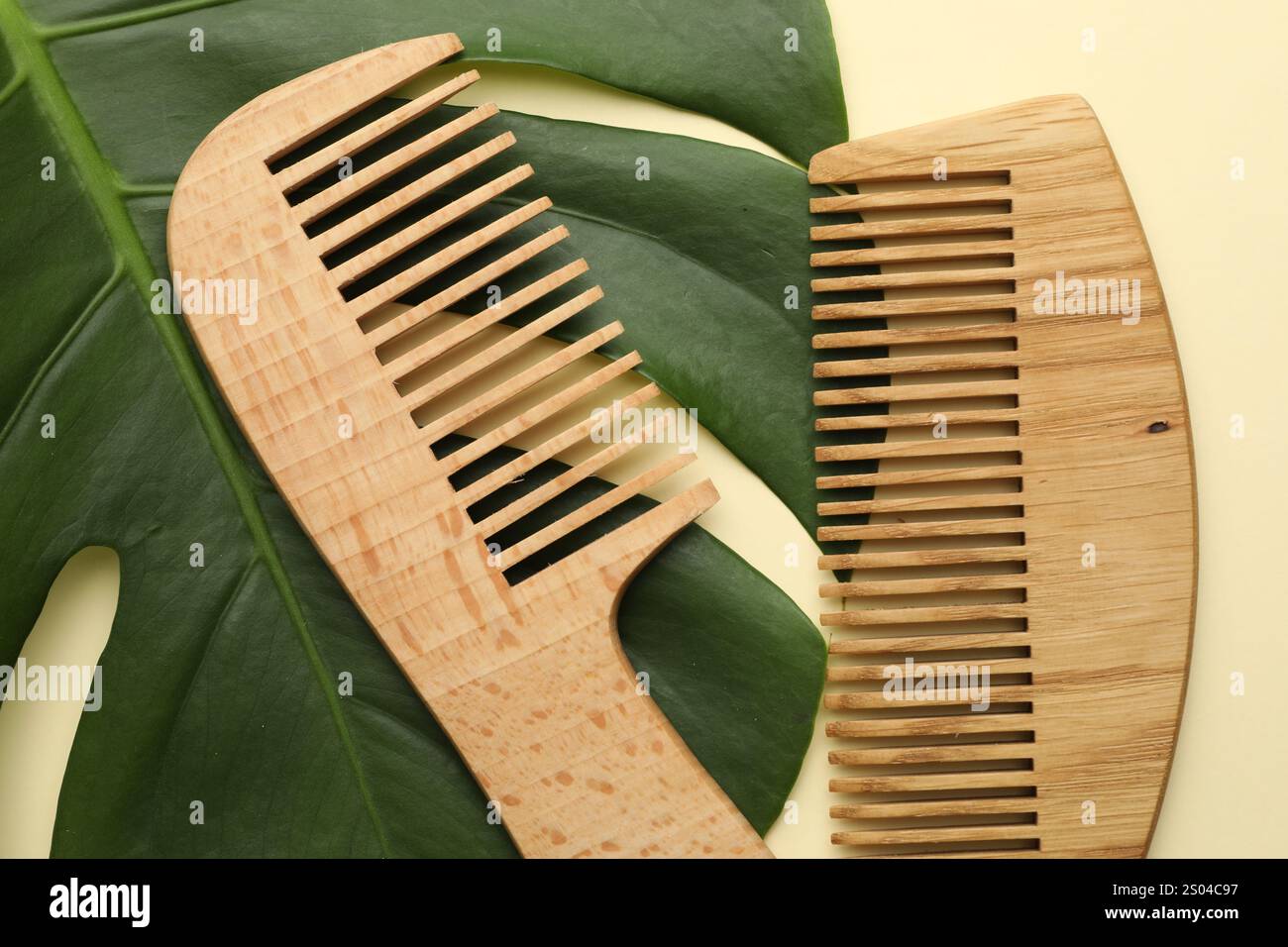 Wooden combs and monstera leaf on beige background, flat lay Stock ...