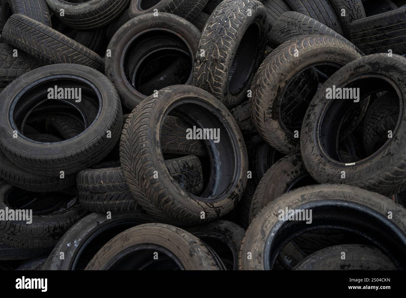 Recycling of used tires. Production of regenerated rubber for tires. A pile of black old car ...