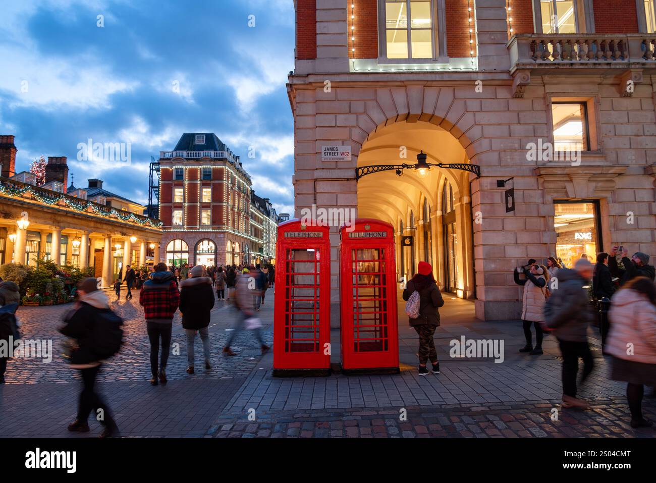 A bustling evening in Covent Garden, London, featuring iconic red ...
