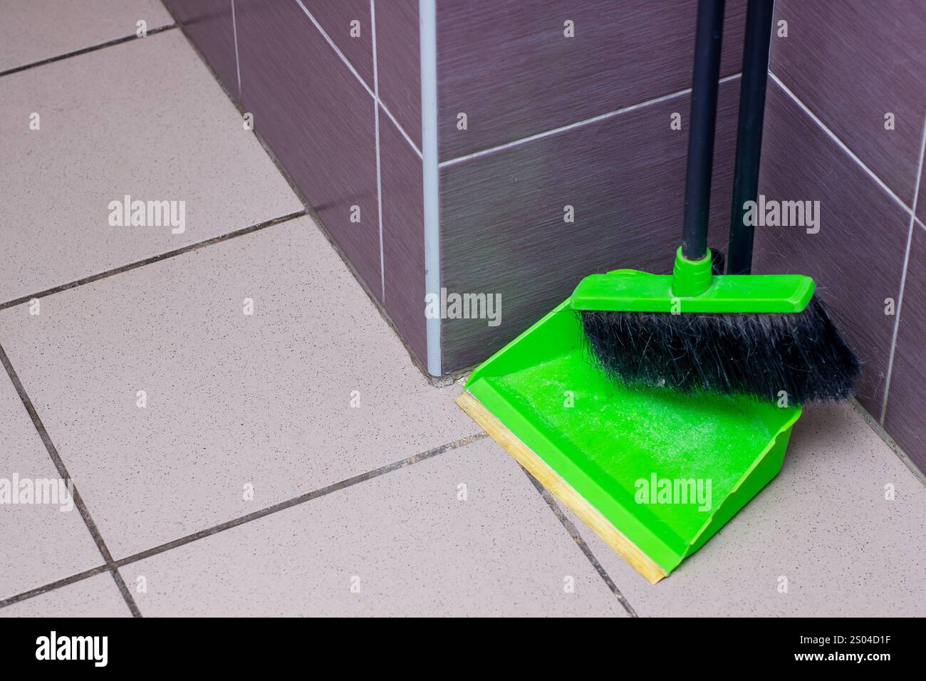 A bright green broom and a matching dustpan resting on a beautifully ...