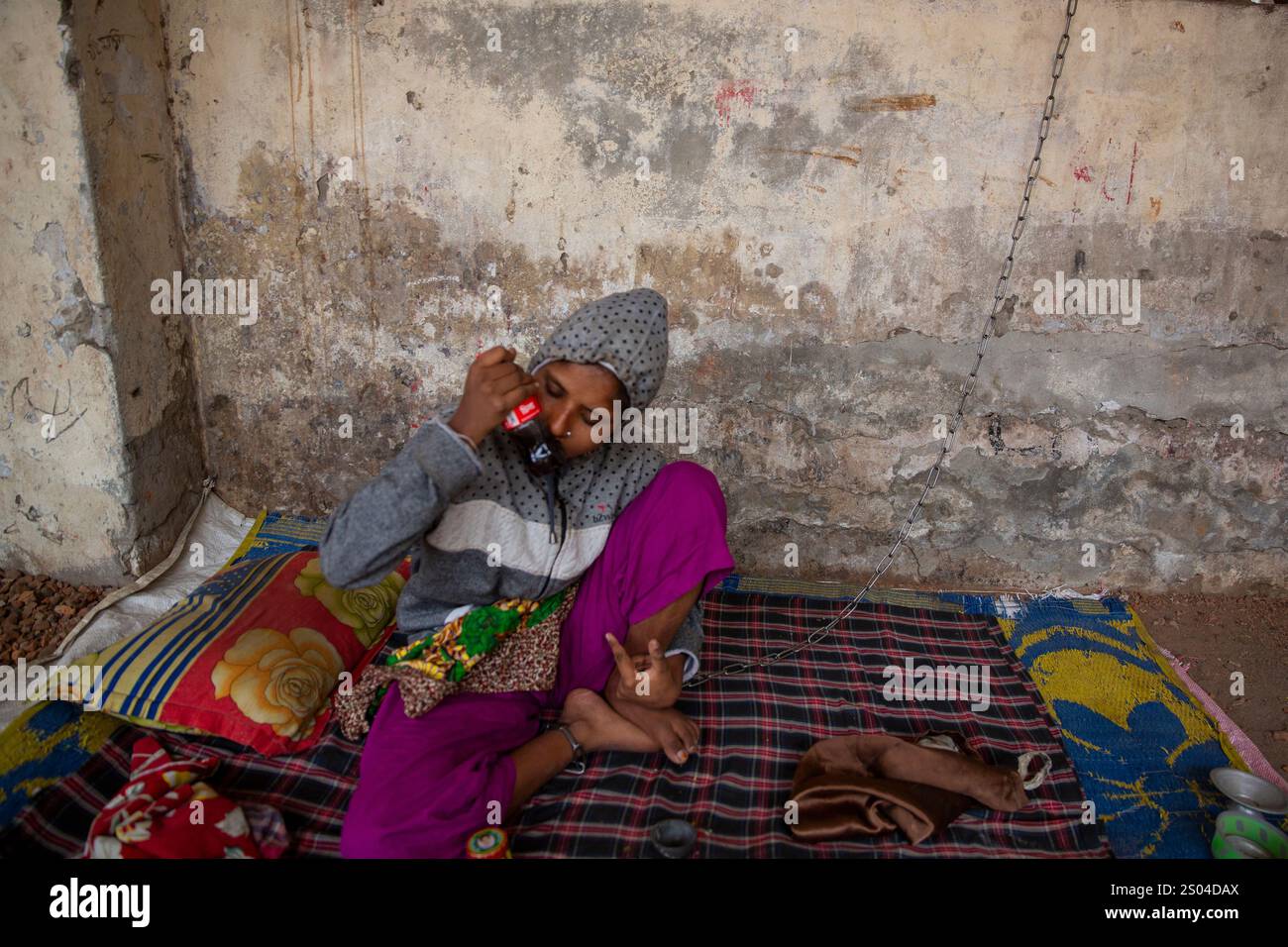 A mentally disabled girl is confined with chains beside a roadside in Dhaka, Bangladesh ...