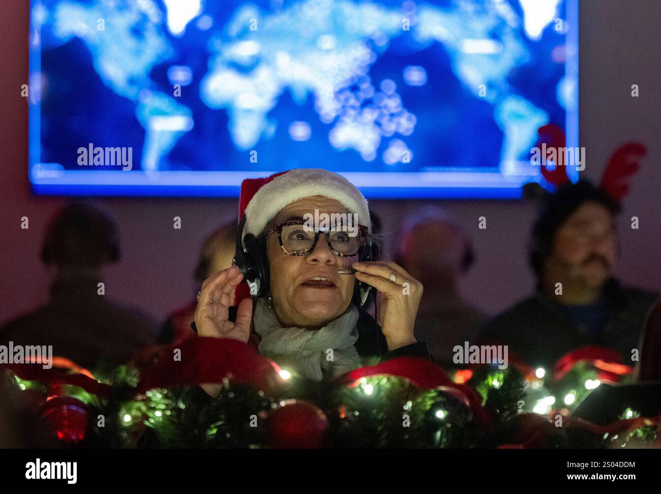 Volunteers answer phone calls from around the world Tuesday, Dec. 24, 2024, at the NORAD Tracks ...