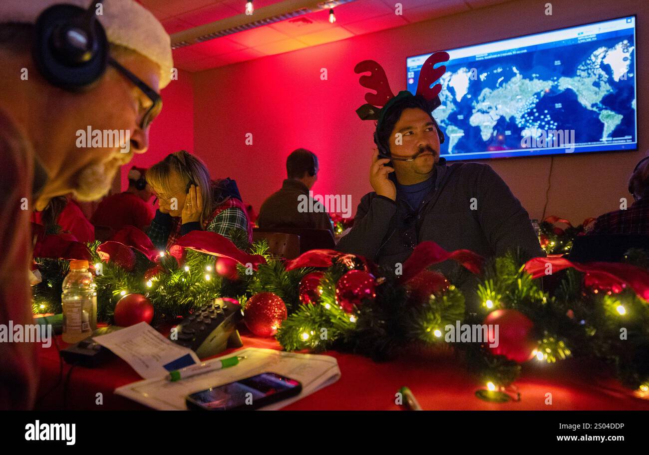 Volunteers answer phone calls from around the world Tuesday, Dec. 24, 2024, at the NORAD Tracks ...