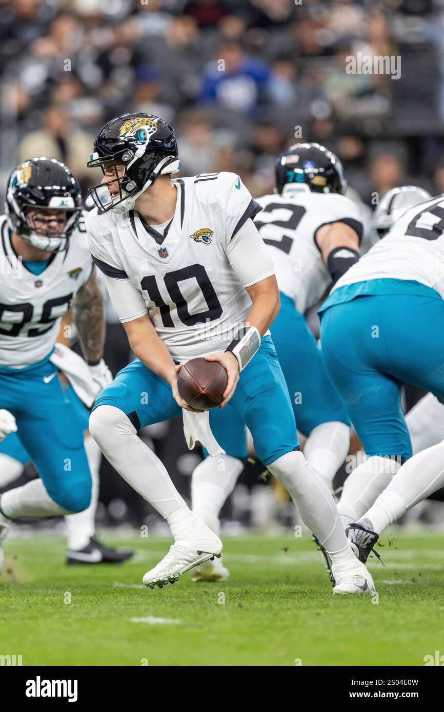 Jacksonville Jaguars quarterback Mac Jones (10) turns to pitch the ball ...