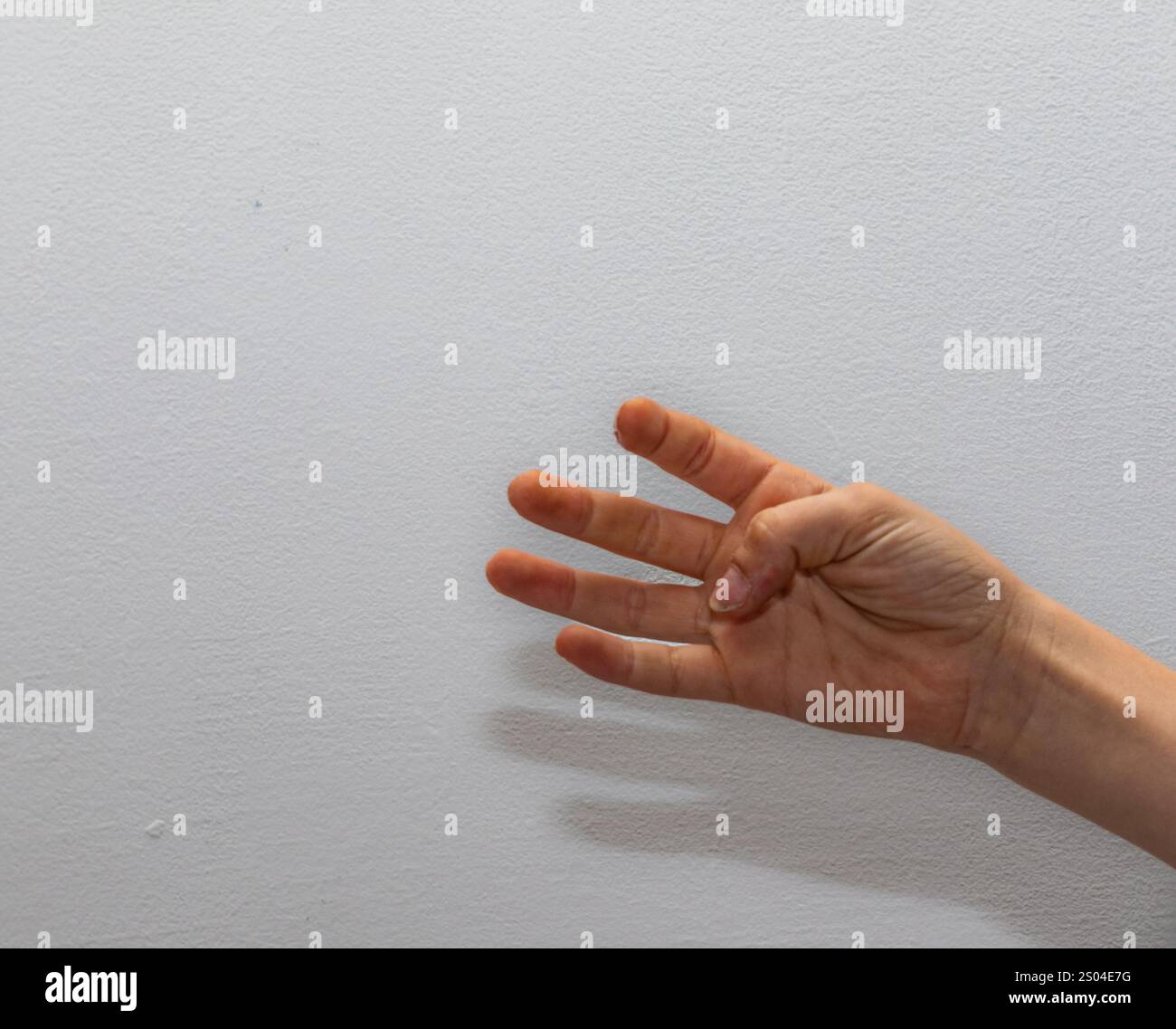 human hand displays the number four with fingers against a plain white ...