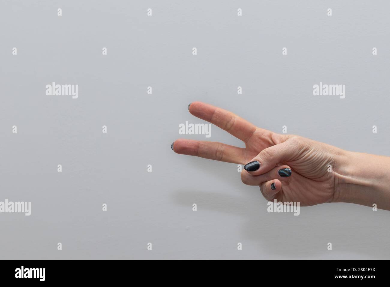 detailed view of a woman's hand with two fingers raised against a ...