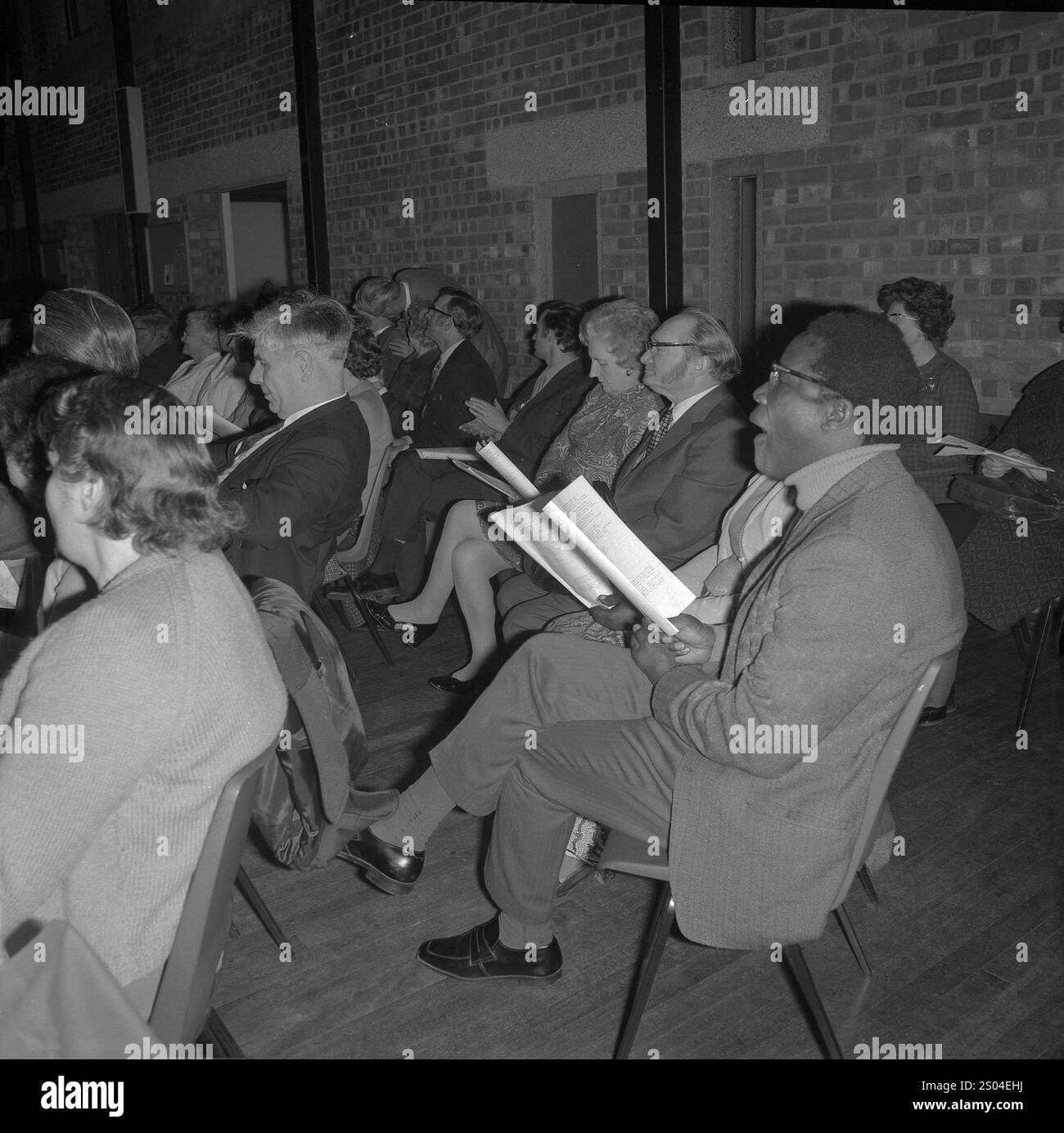 1974, historical, people sitting singing inside a parish church ...