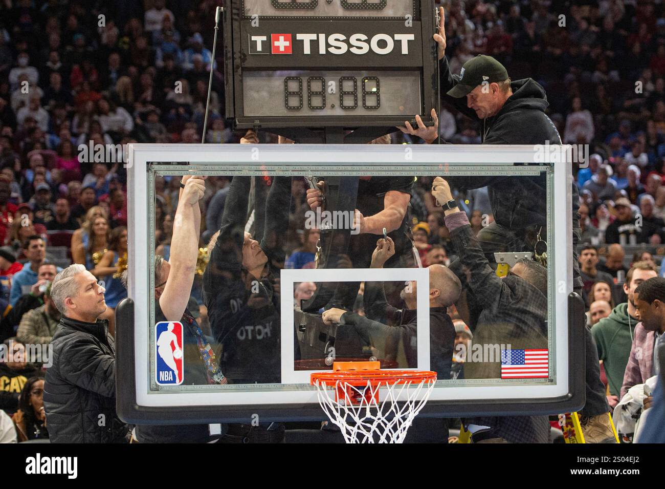 Workers try to repair a defective backboard and basket before the first ...