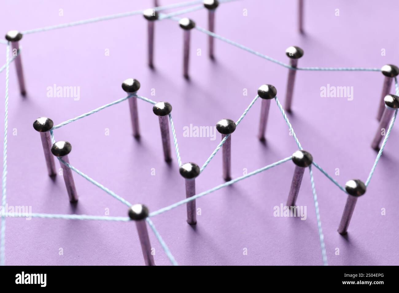 Network connection. Nails linked together by thread on violet ...