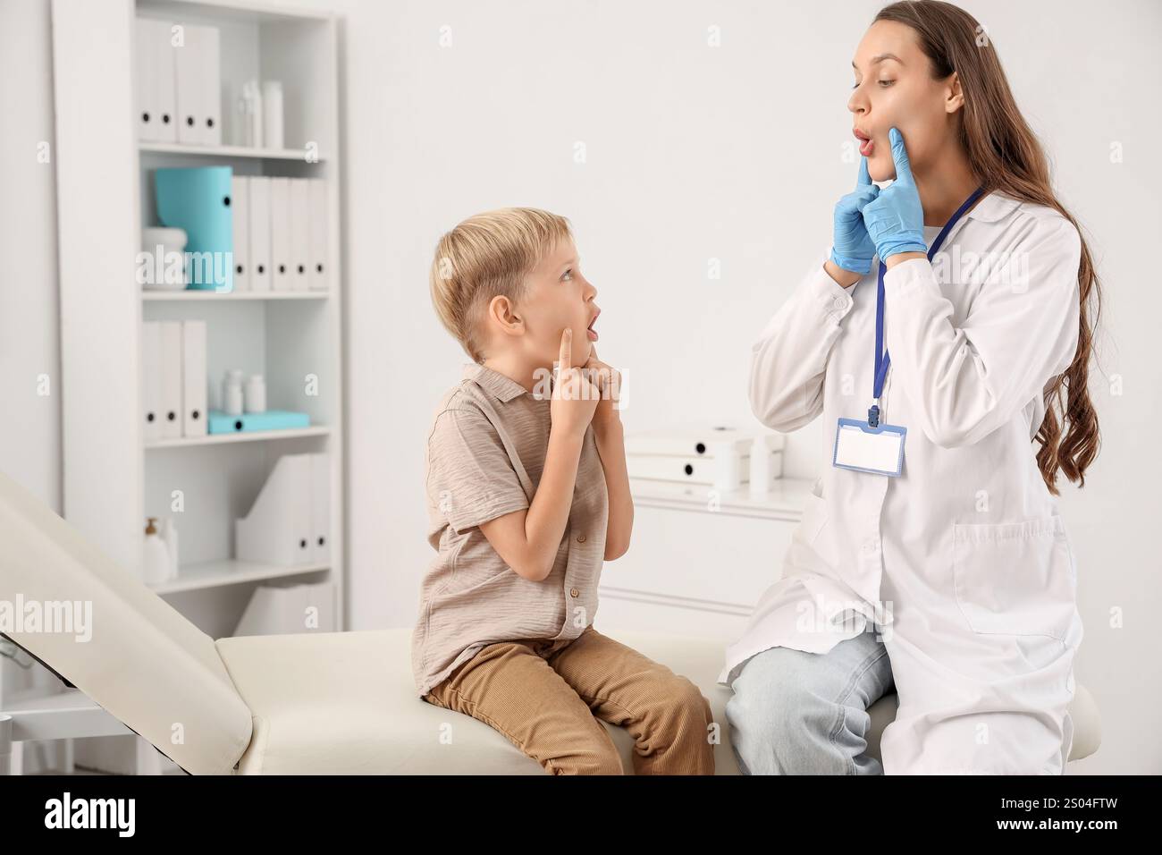 Female speech therapist working with little boy in clinic Stock Photo ...