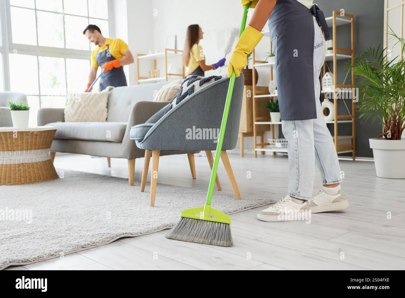 Female janitor sweeping floor in room Stock Photo - Alamy