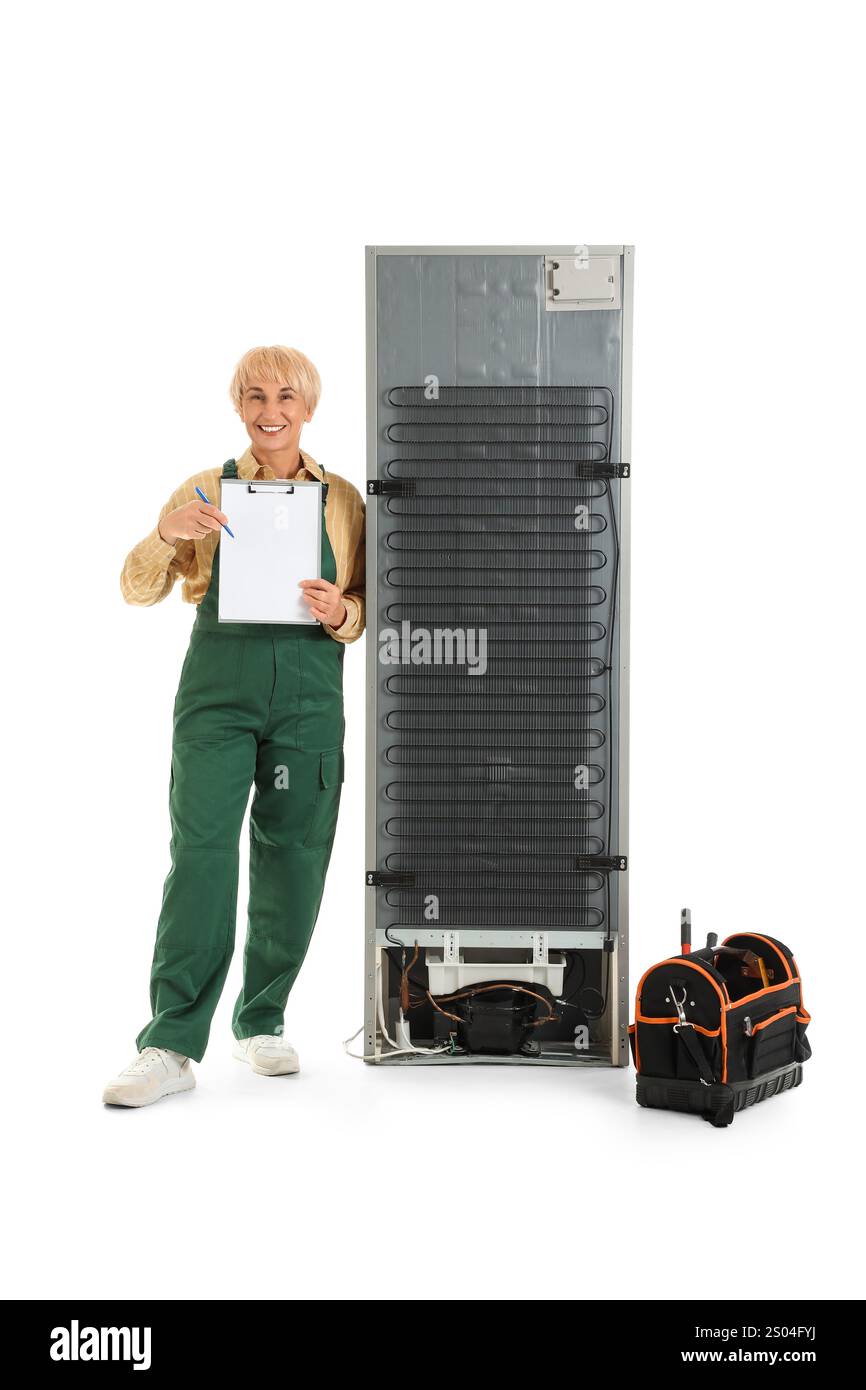 Female worker with clipboard near refrigerator on white background ...