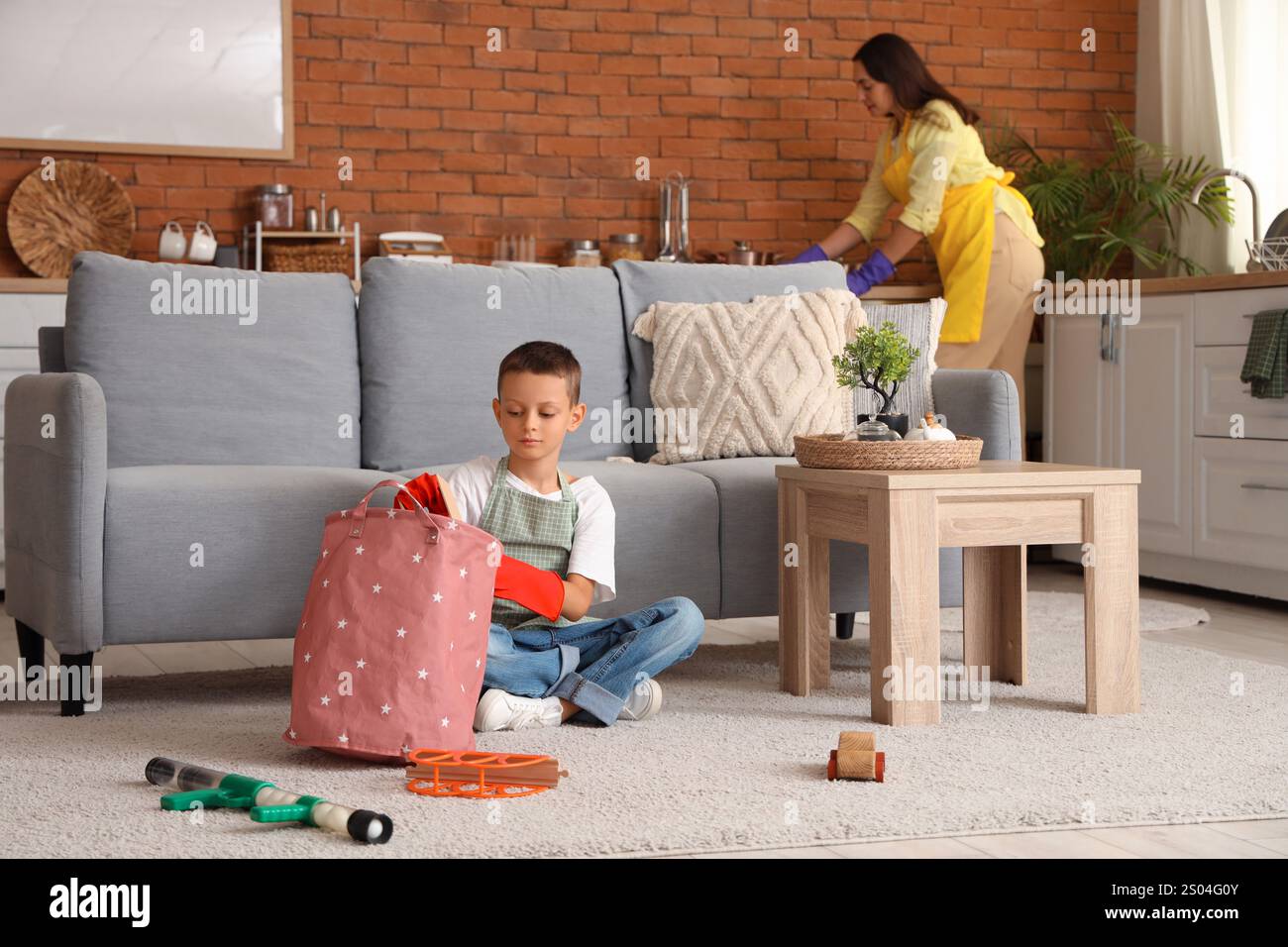 Cute little boy helping his mother with cleaning routine at home Stock ...