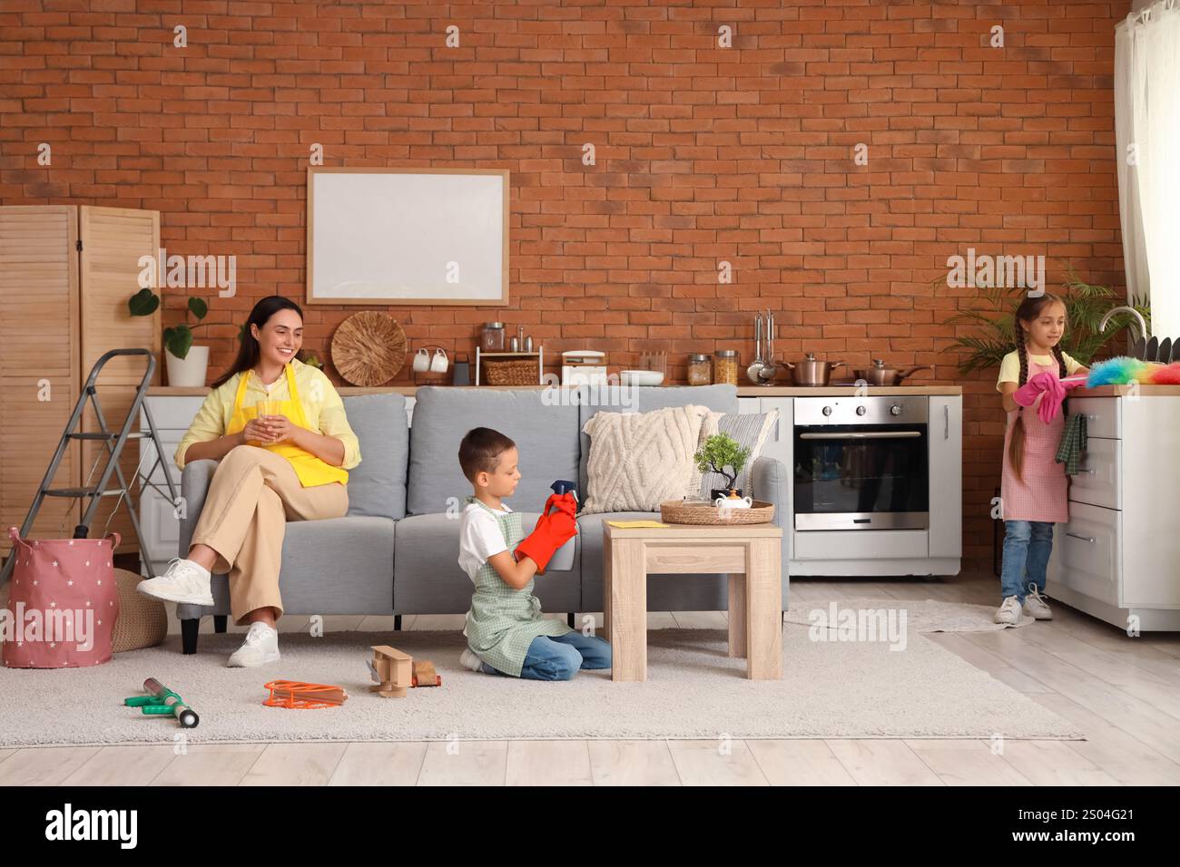 Cute little children helping their mother with cleaning routine at home ...