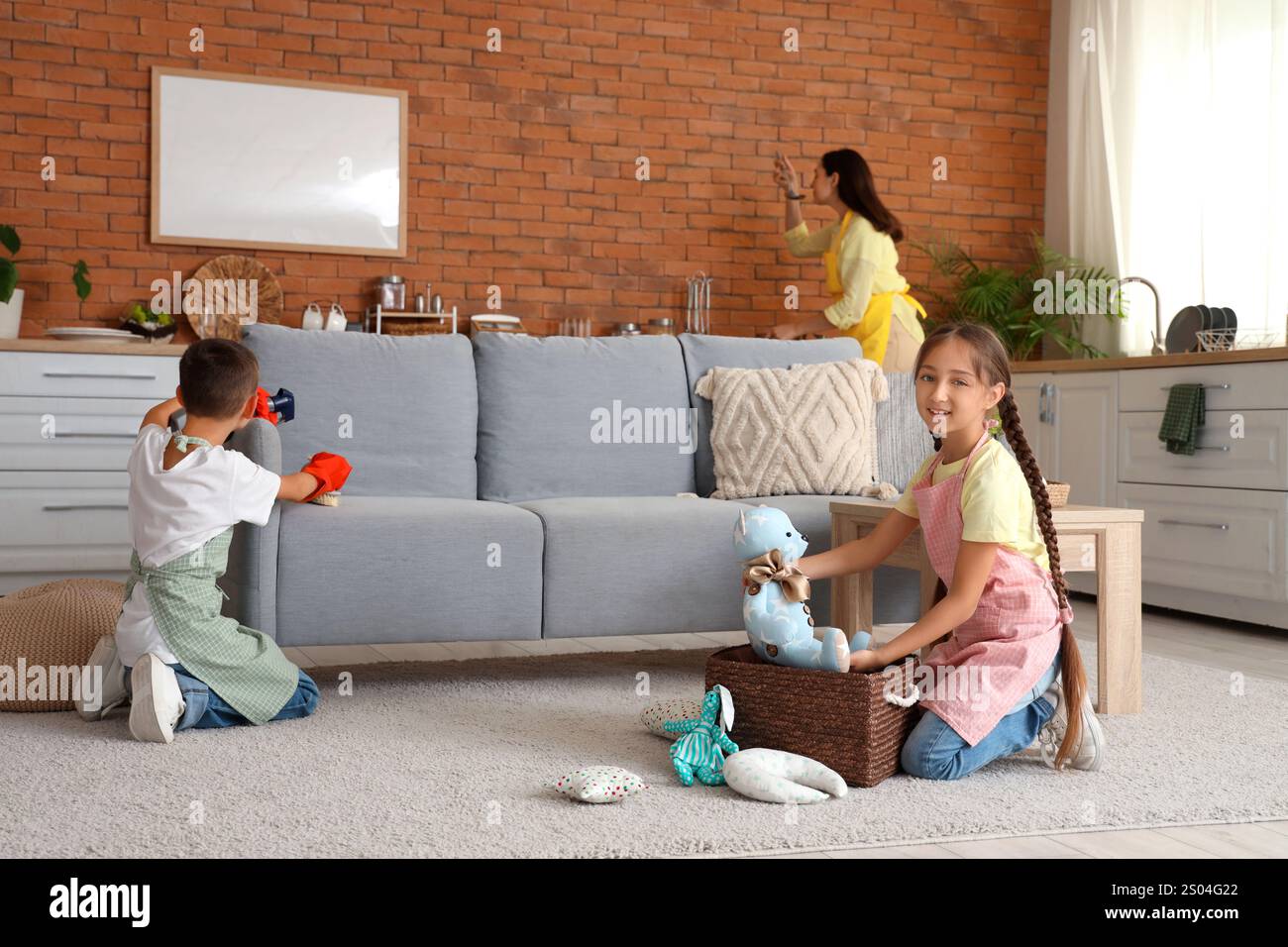 Cute little children helping their mother with cleaning routine at home ...