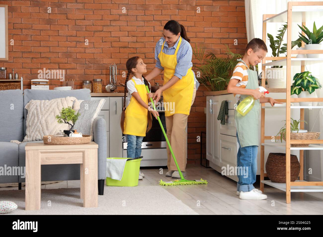 Cute little children helping their mother with cleaning routine at home ...