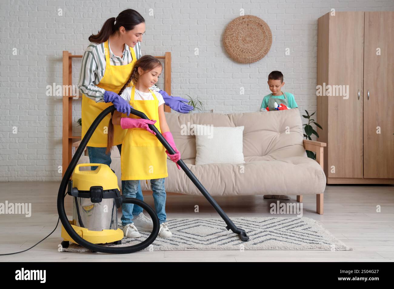 Cute little children helping their mother with cleaning routine at home ...