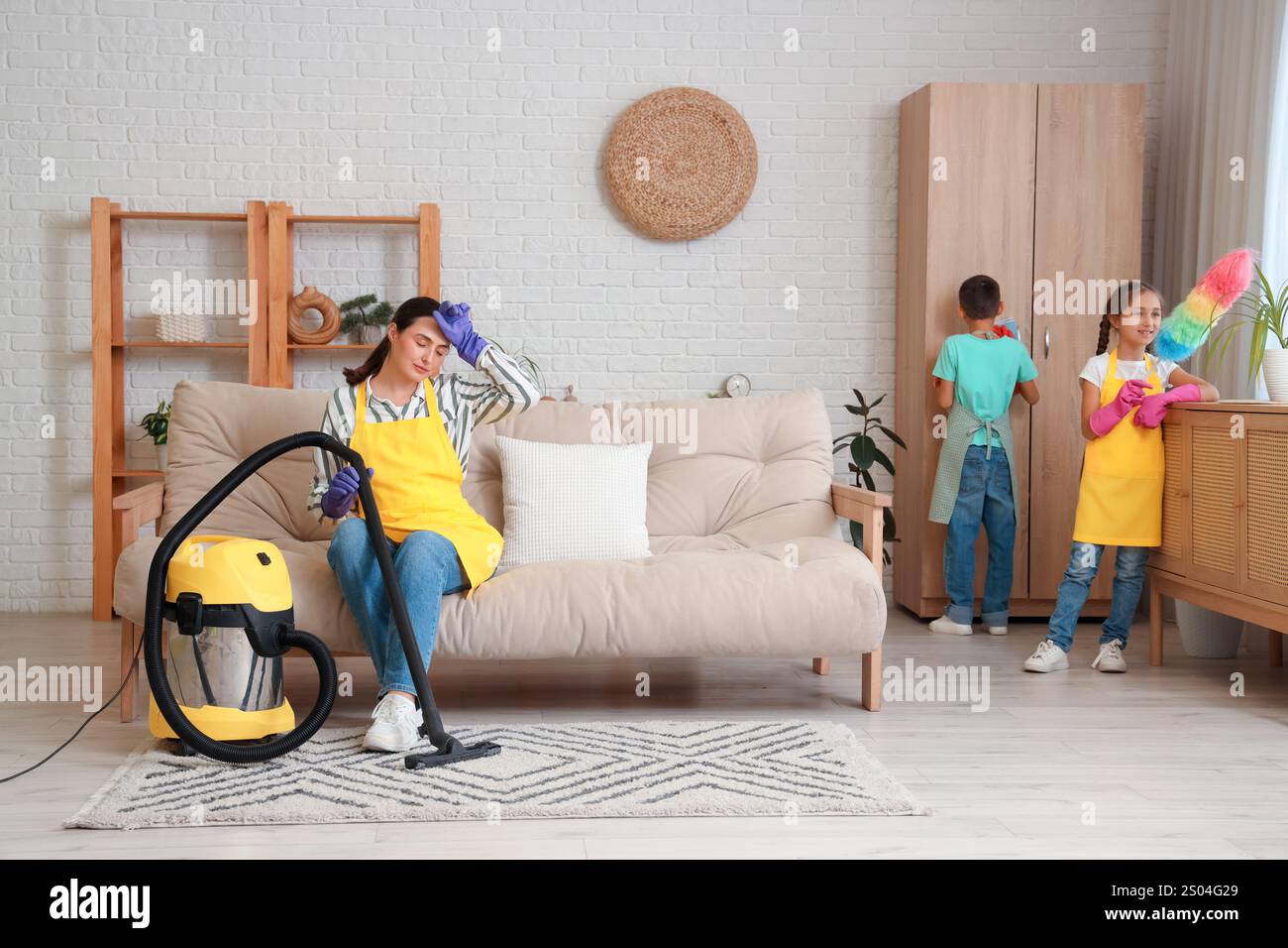 Cute little children helping their tired mother with cleaning routine ...