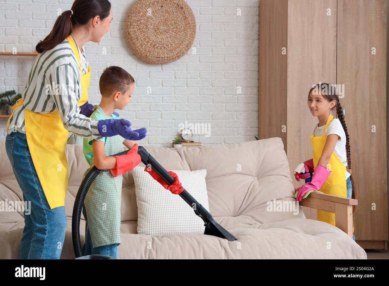 Cute little children helping their mother with cleaning routine at home ...