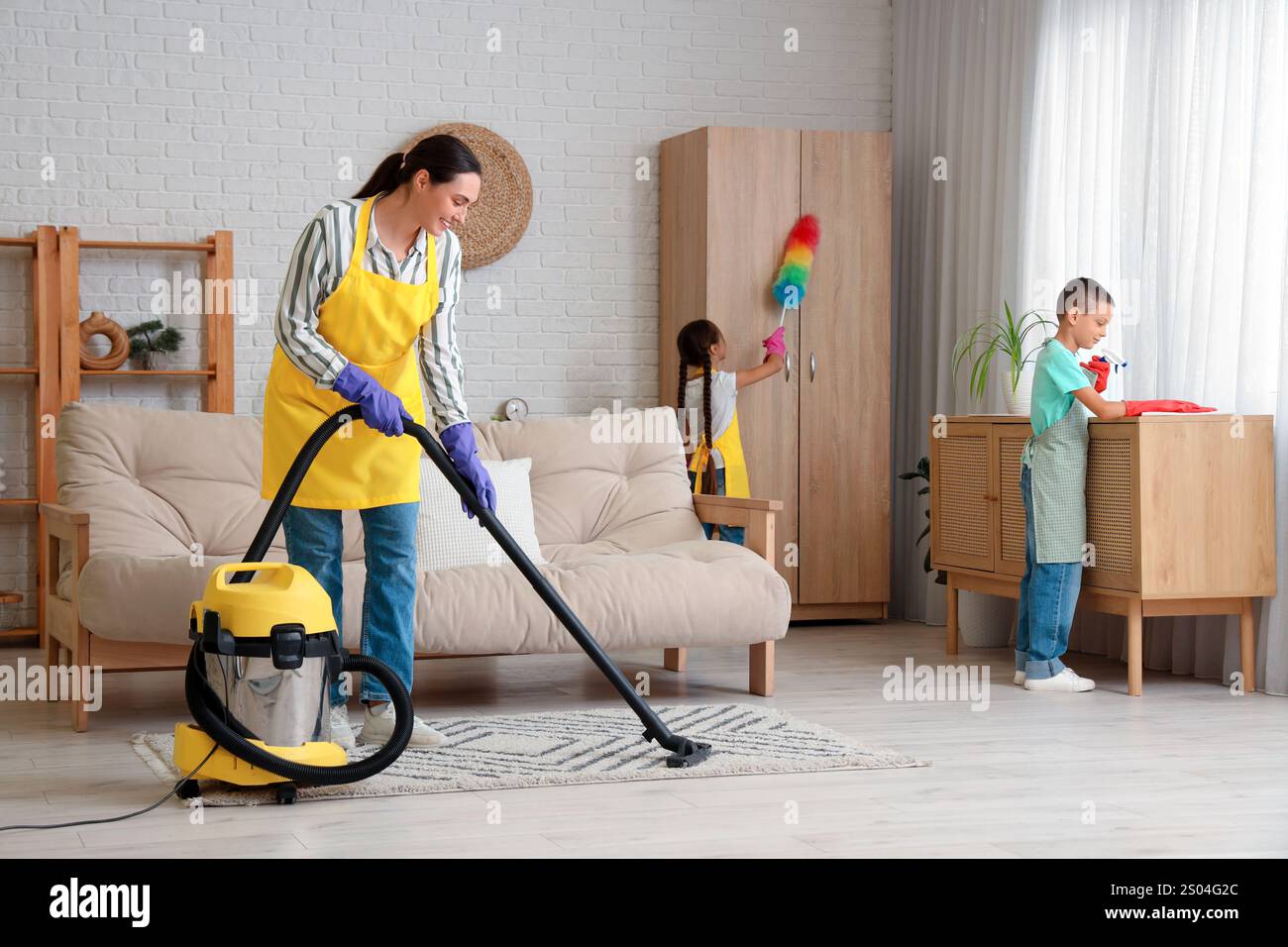 Cute little children helping their mother with cleaning routine at home ...