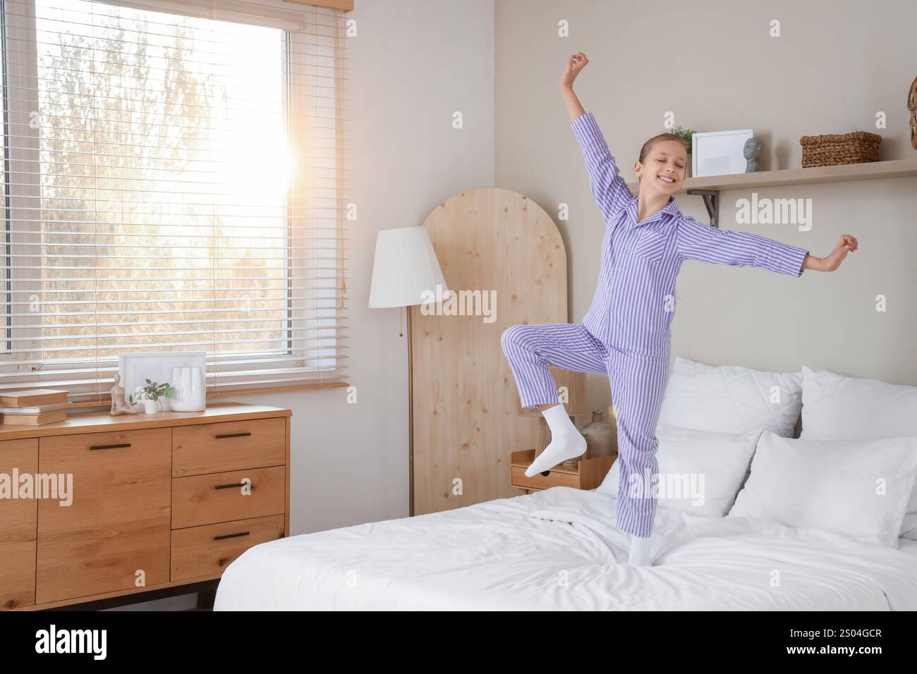 Teenage girl stretching on bed in bedroom Stock Photo - Alamy