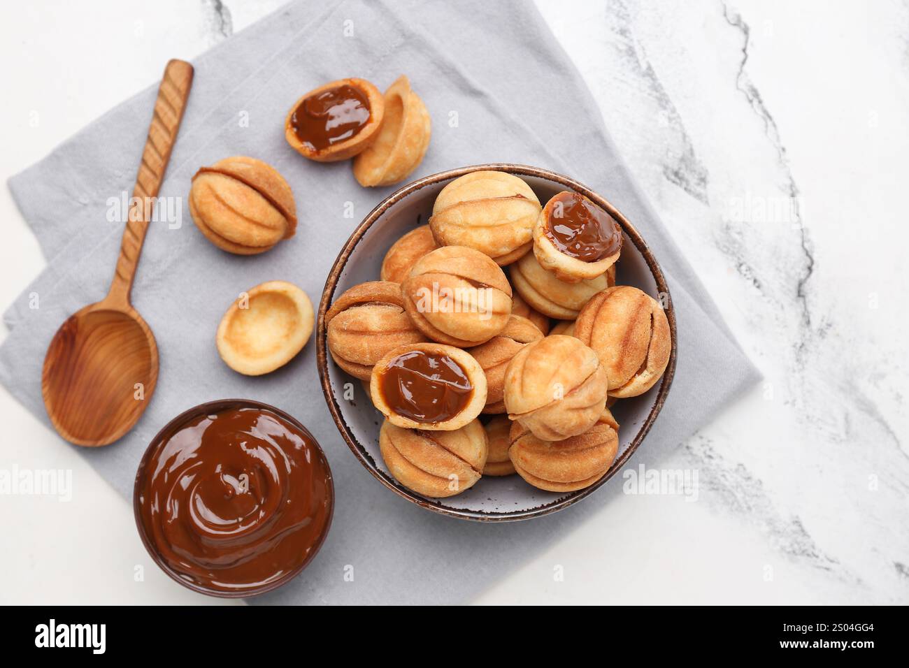 Bowl of sweet walnut shaped cookies with boiled condensed milk on white ...