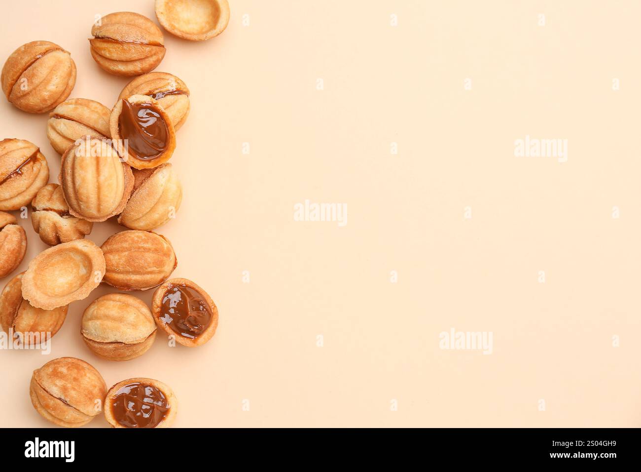 Sweet walnut shaped cookies with boiled condensed milk on beige ...