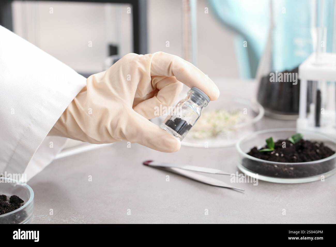 Scientist holding ampule with sample of soil in laboratory, closeup ...