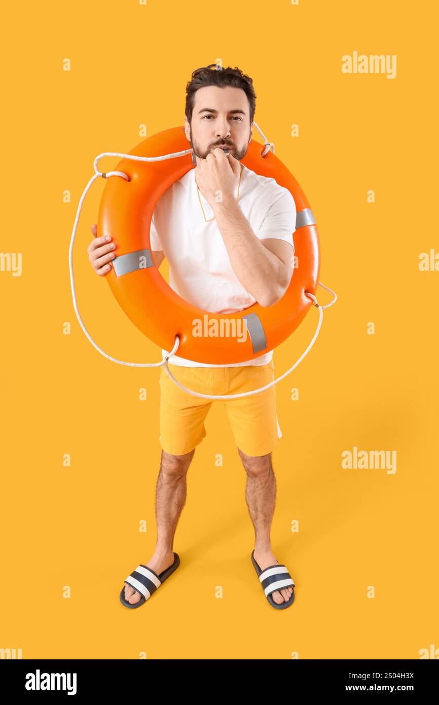 Beach rescuer with lifebuoy and whistle on yellow background Stock ...