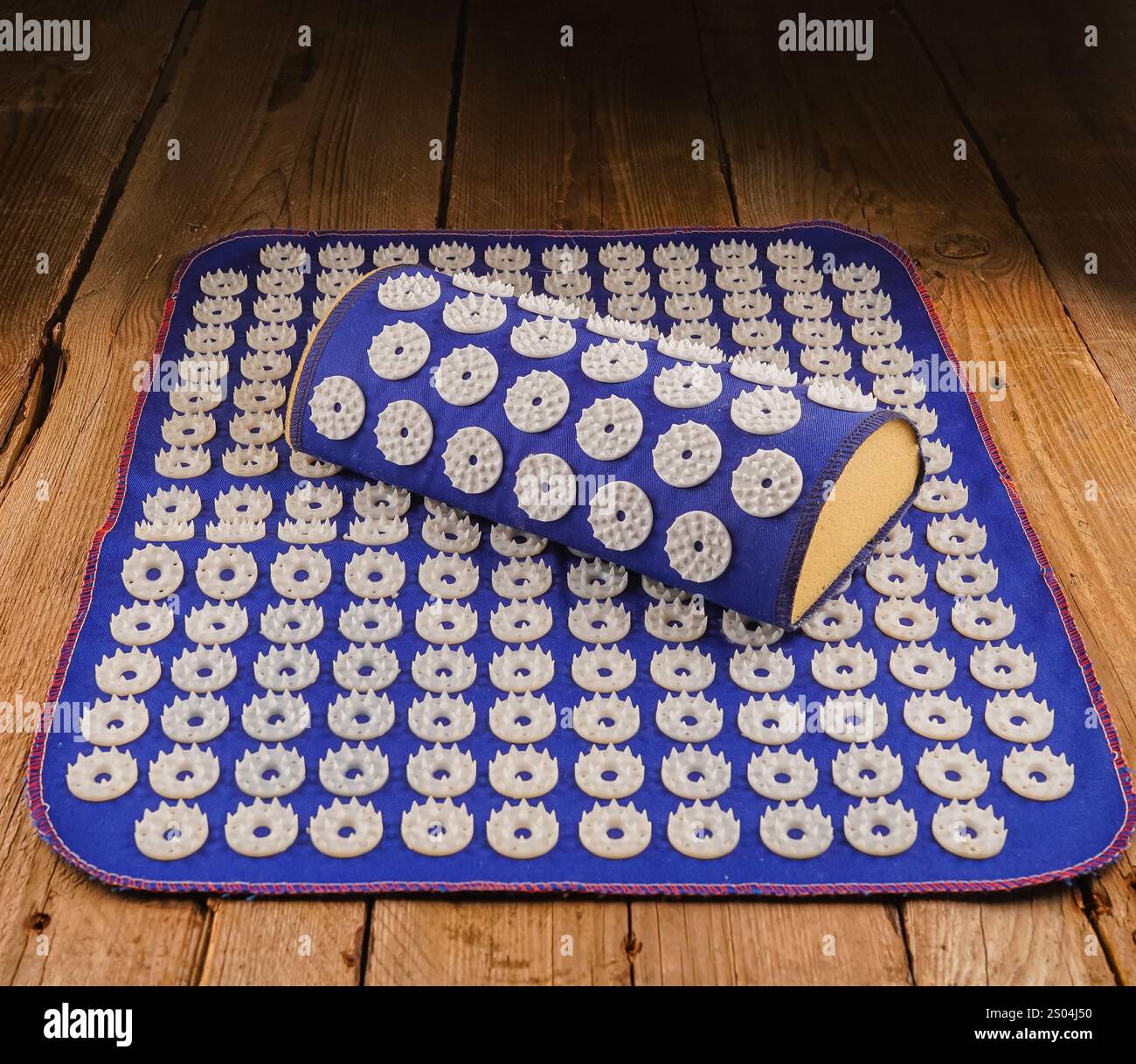 The blue acupressure mat features a textured design for massage. This ...