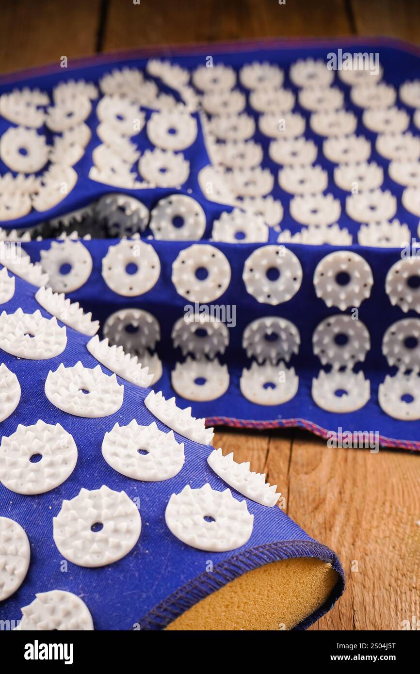 The blue acupressure mat features a textured design for massage. This ...